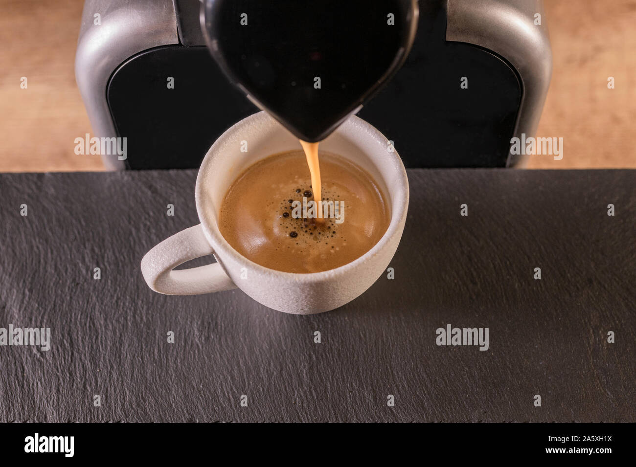 Top view of a coffee machine with a white coffee cup underneath - Close ...