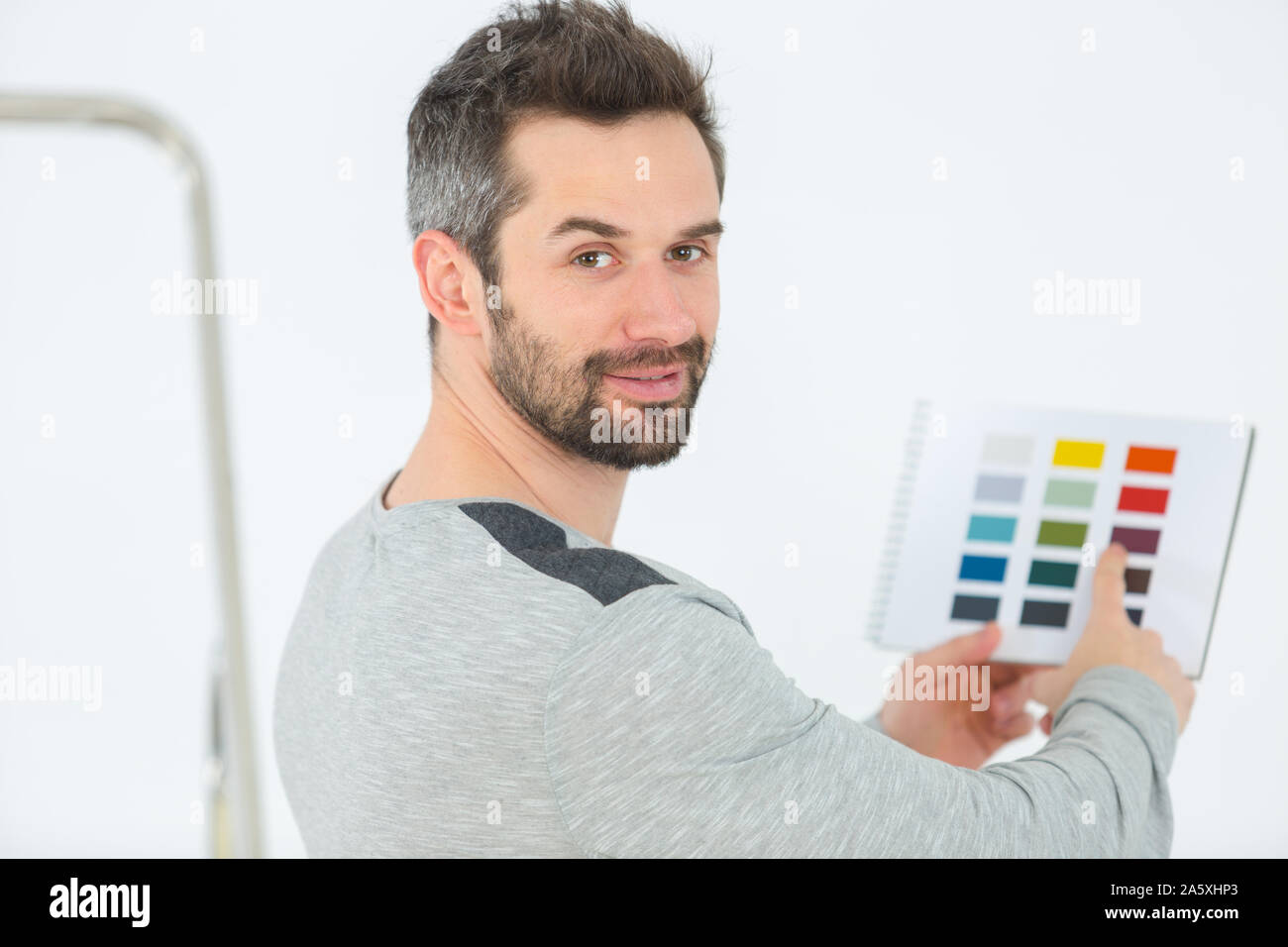 worker holding palette for choosing color of wall Stock Photo - Alamy