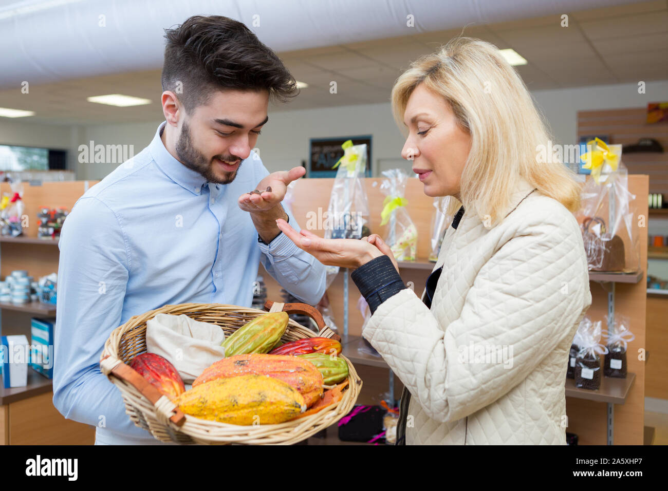 customer with retailer holding fruits and smelling sample Stock Photo ...