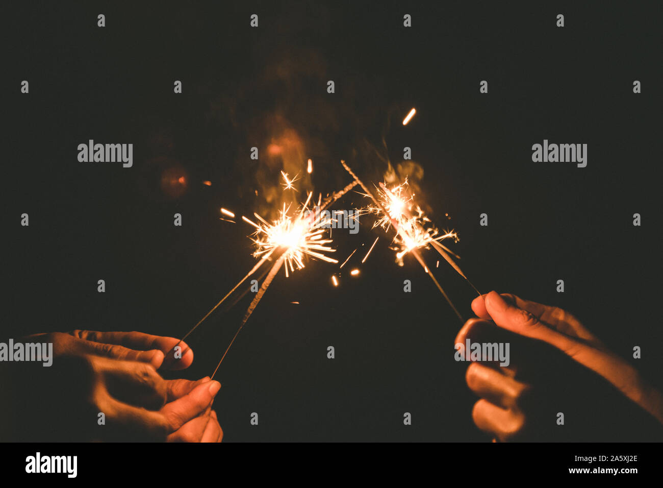 Closeup image of hands holding sparklers for celebrate in the night ...