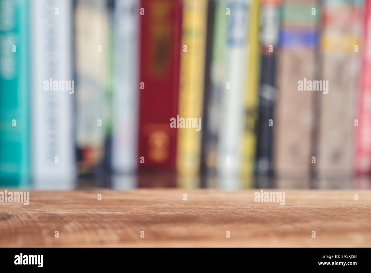 Wooden table and blur bookshelf in background Stock Photo - Alamy