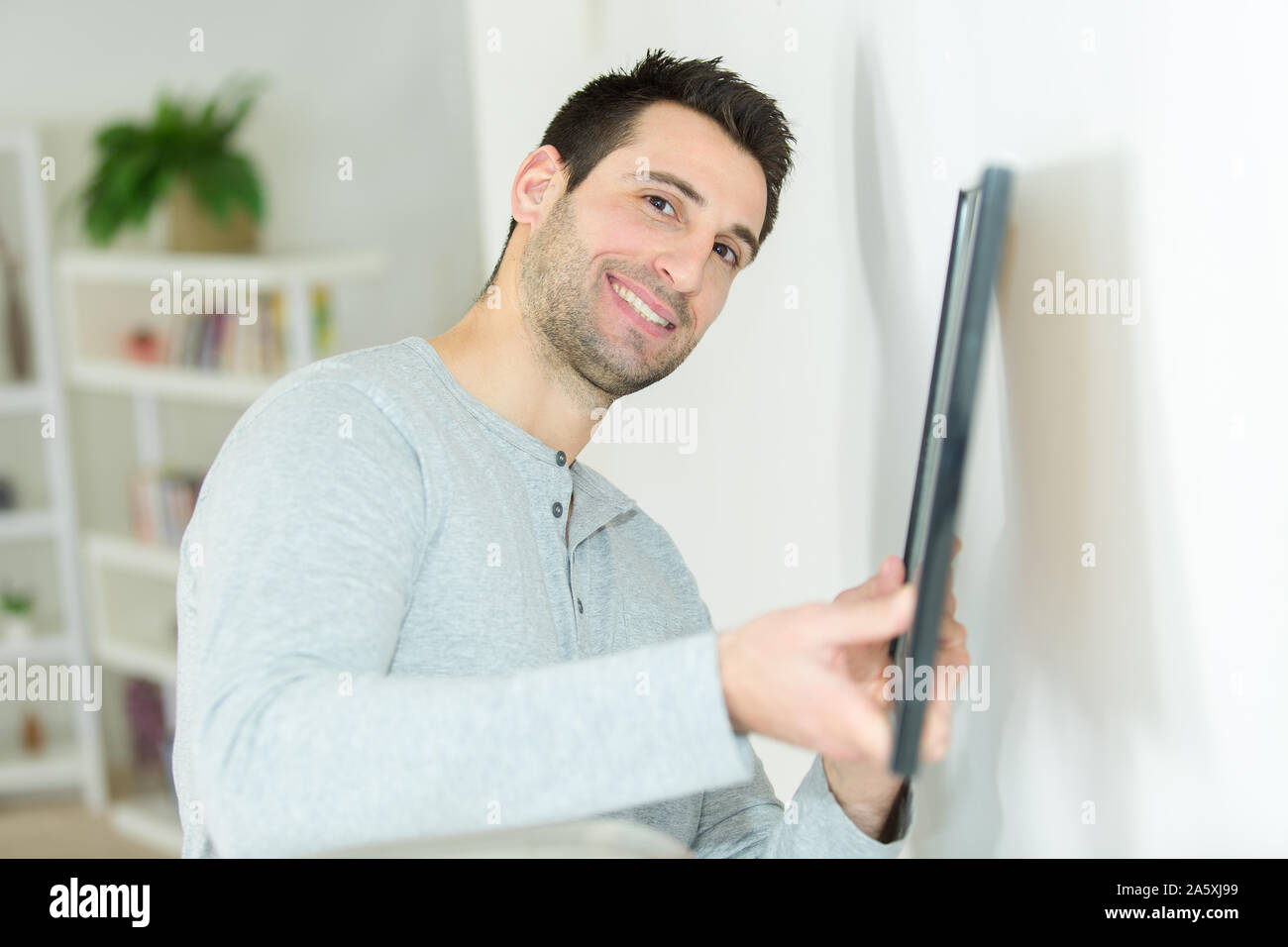 Person hanging paintings hi-res stock photography and images - Alamy