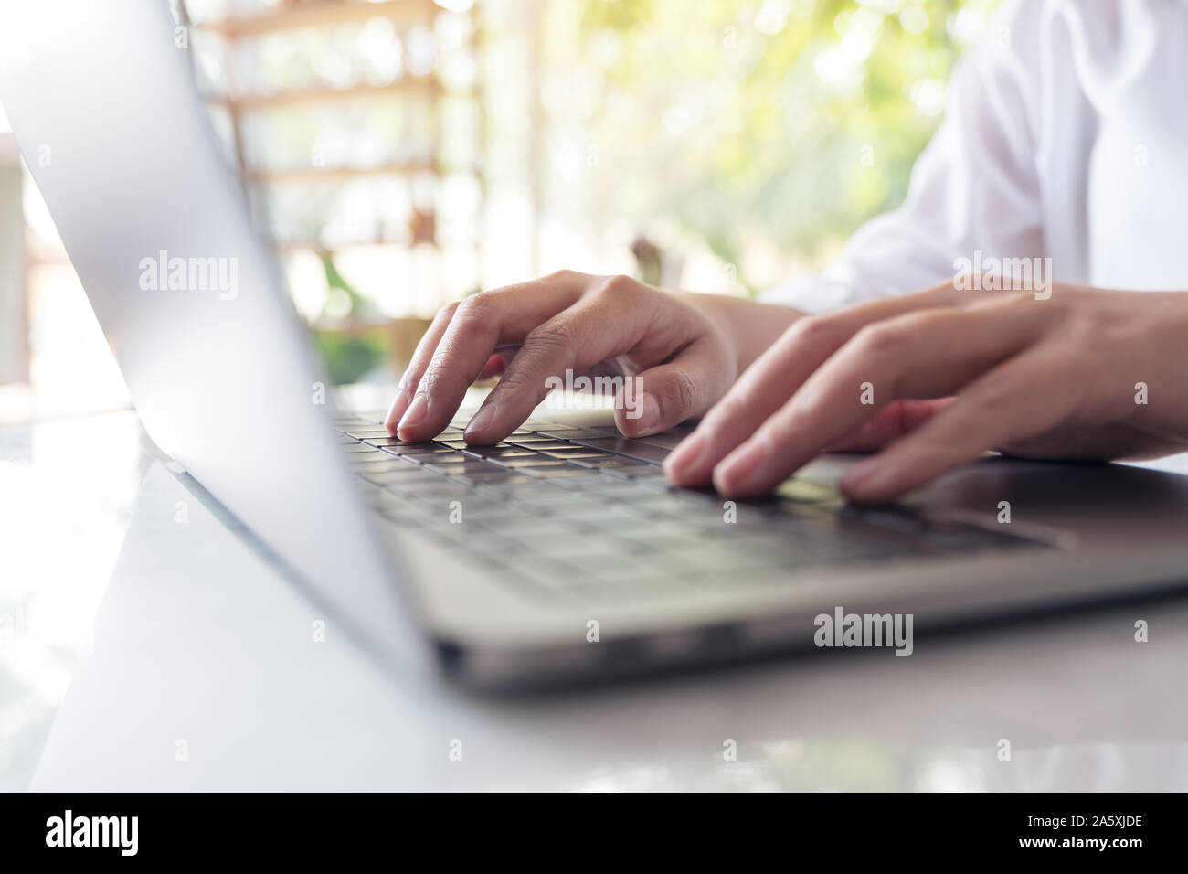 Closeup image of hands working and typing on laptop keyboard on table ...