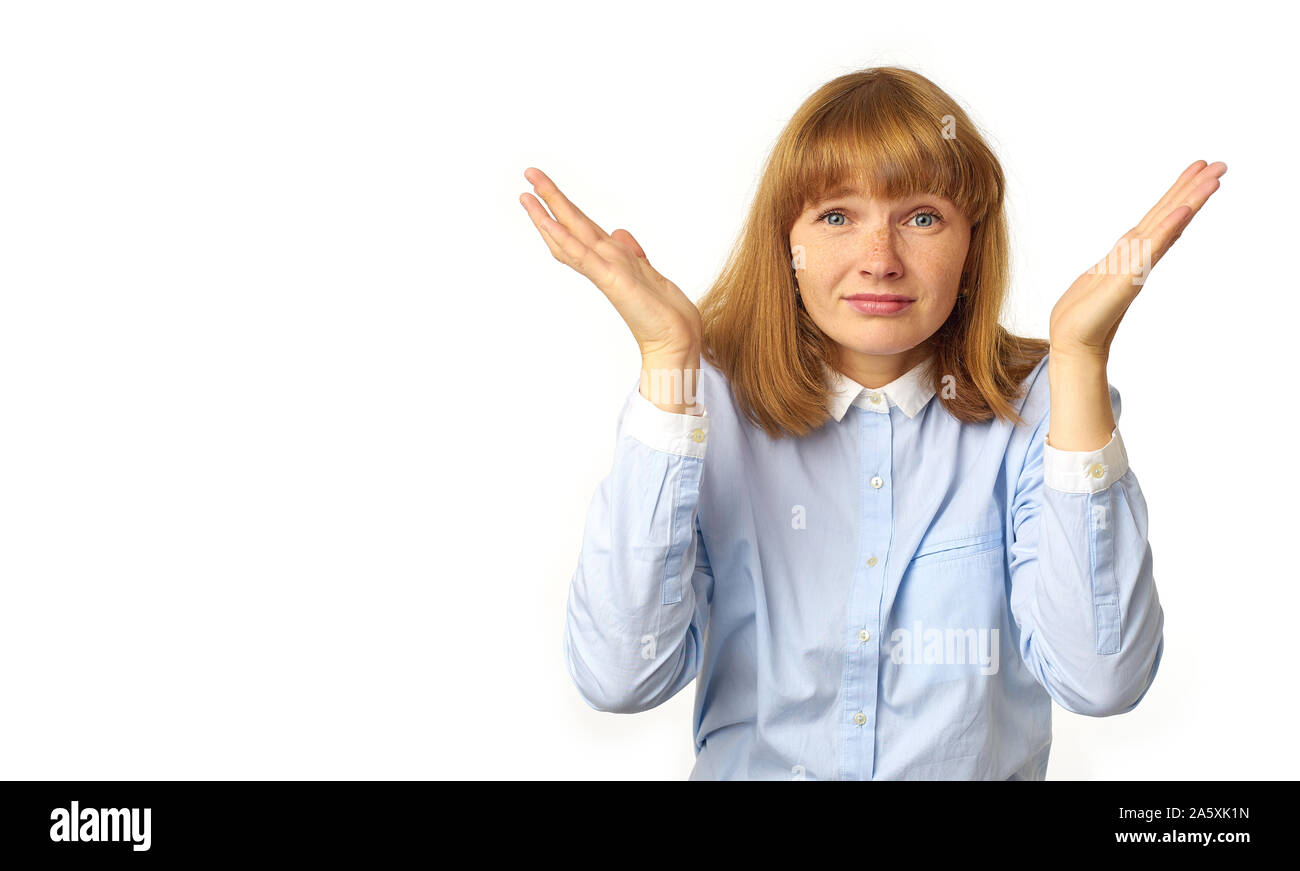 Cute redheaded young woman looking perplexed and shrugging as if ...