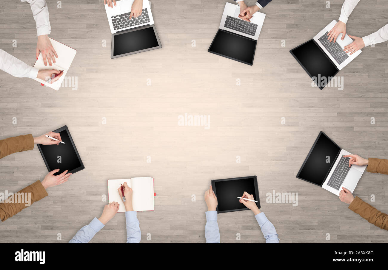 Group of people with devices in hands having desk discussion and making ...