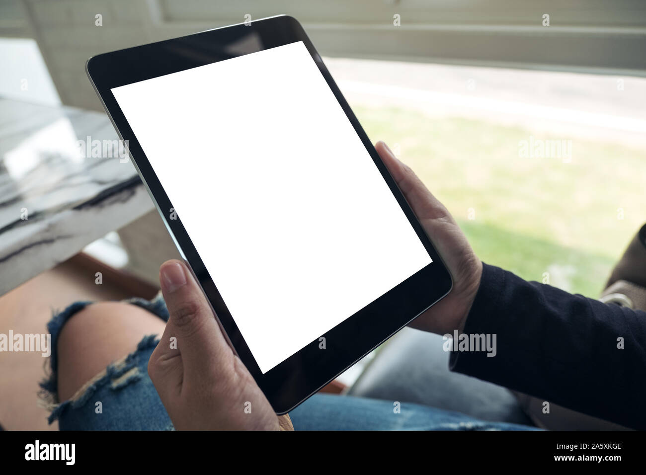 Mockup image of hands holding black tablet with blank white desktop ...