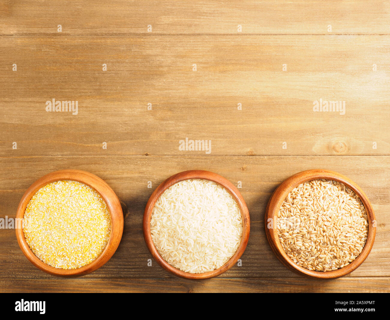 Rice, corn flakes, oat on brown wooden background. Indian cuisine ...
