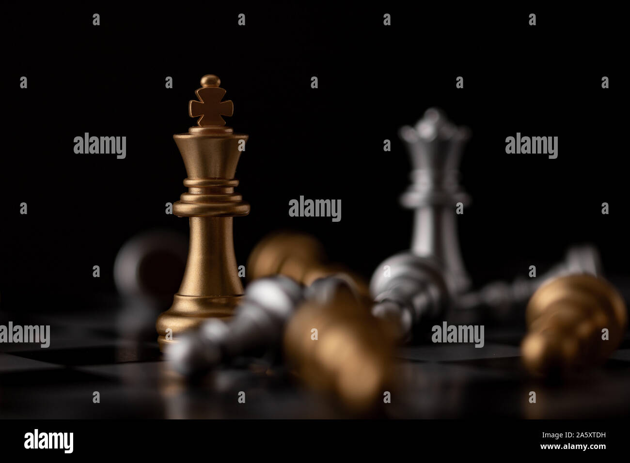 King and Queen standing in the midst of falling chess on board Stock ...