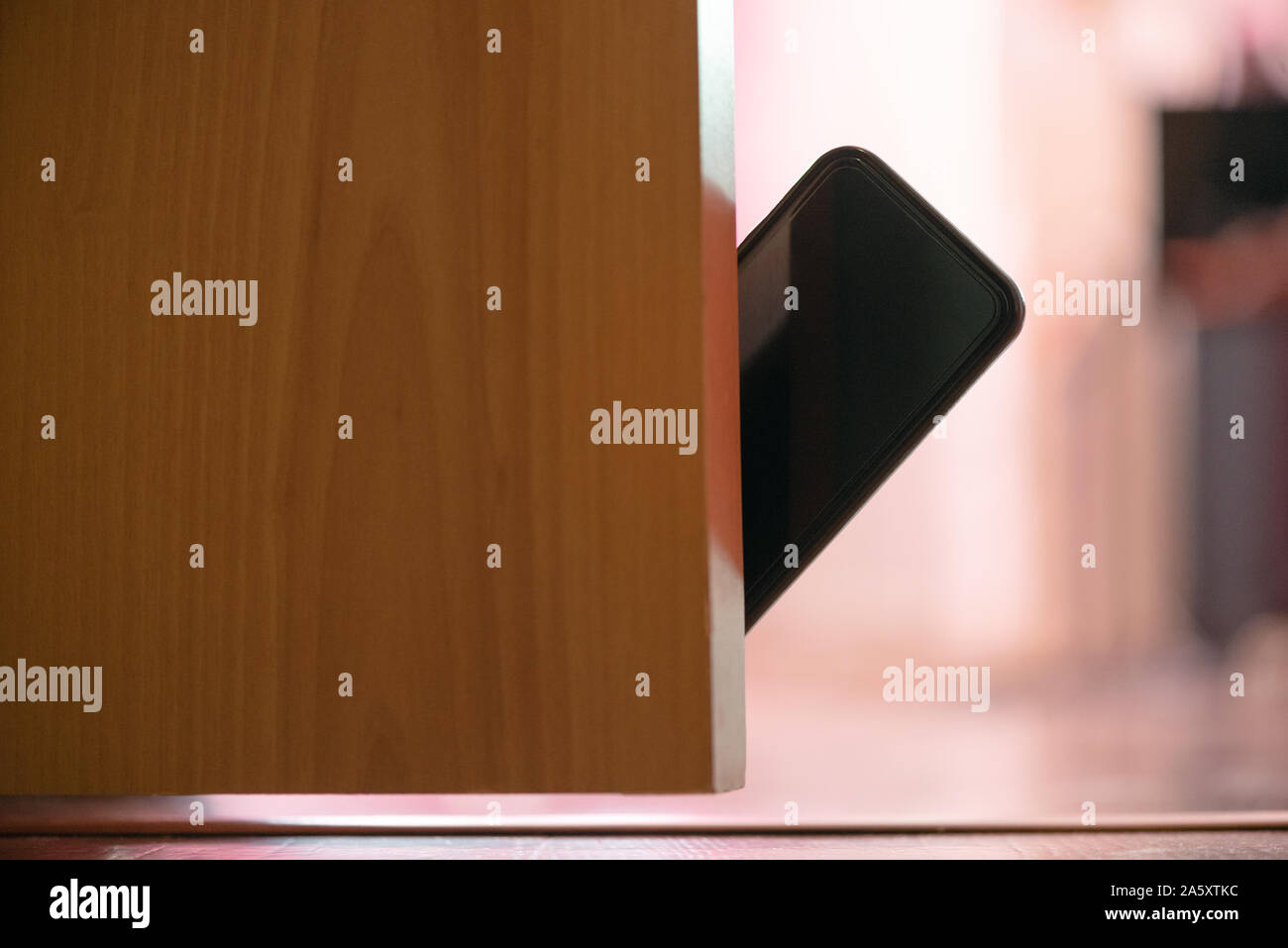 Mobile phone is hiding behind a door in the living room and doing a ...