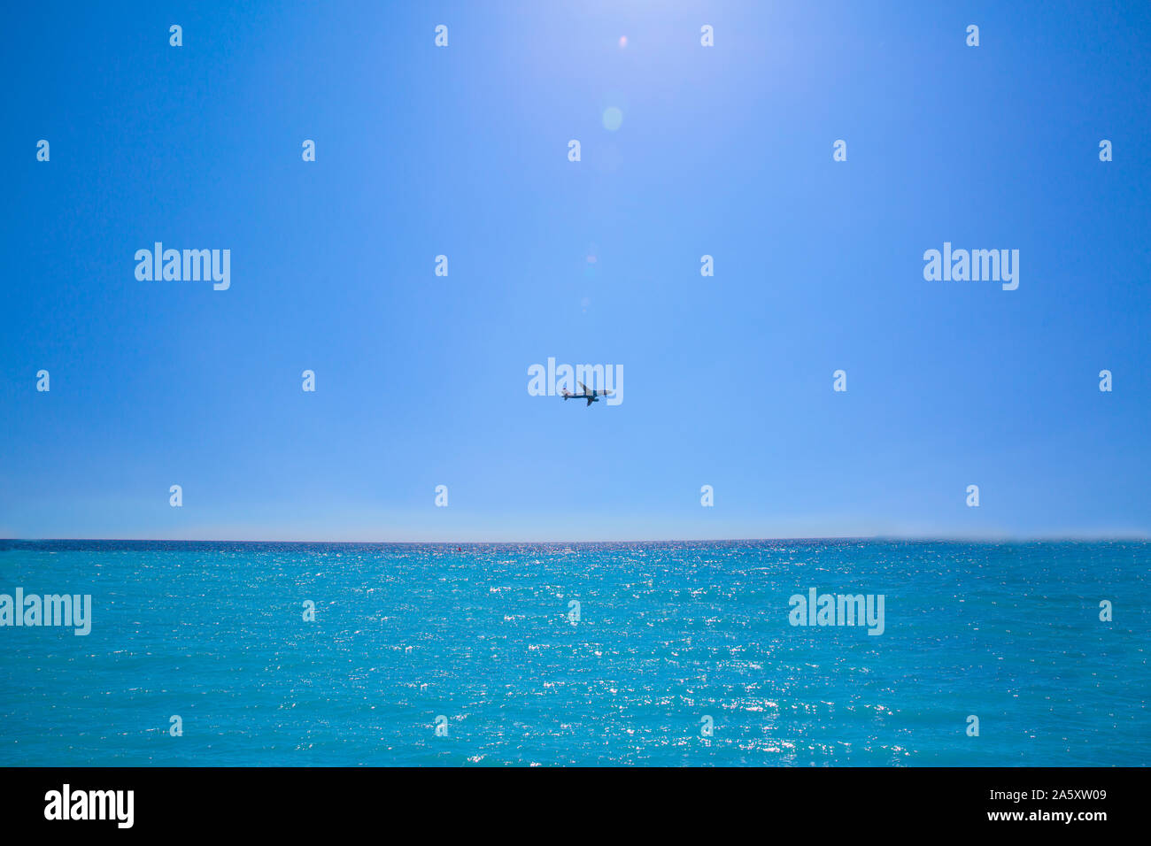 Plane and azure blue sea on horizon. Travel concept Stock Photo - Alamy