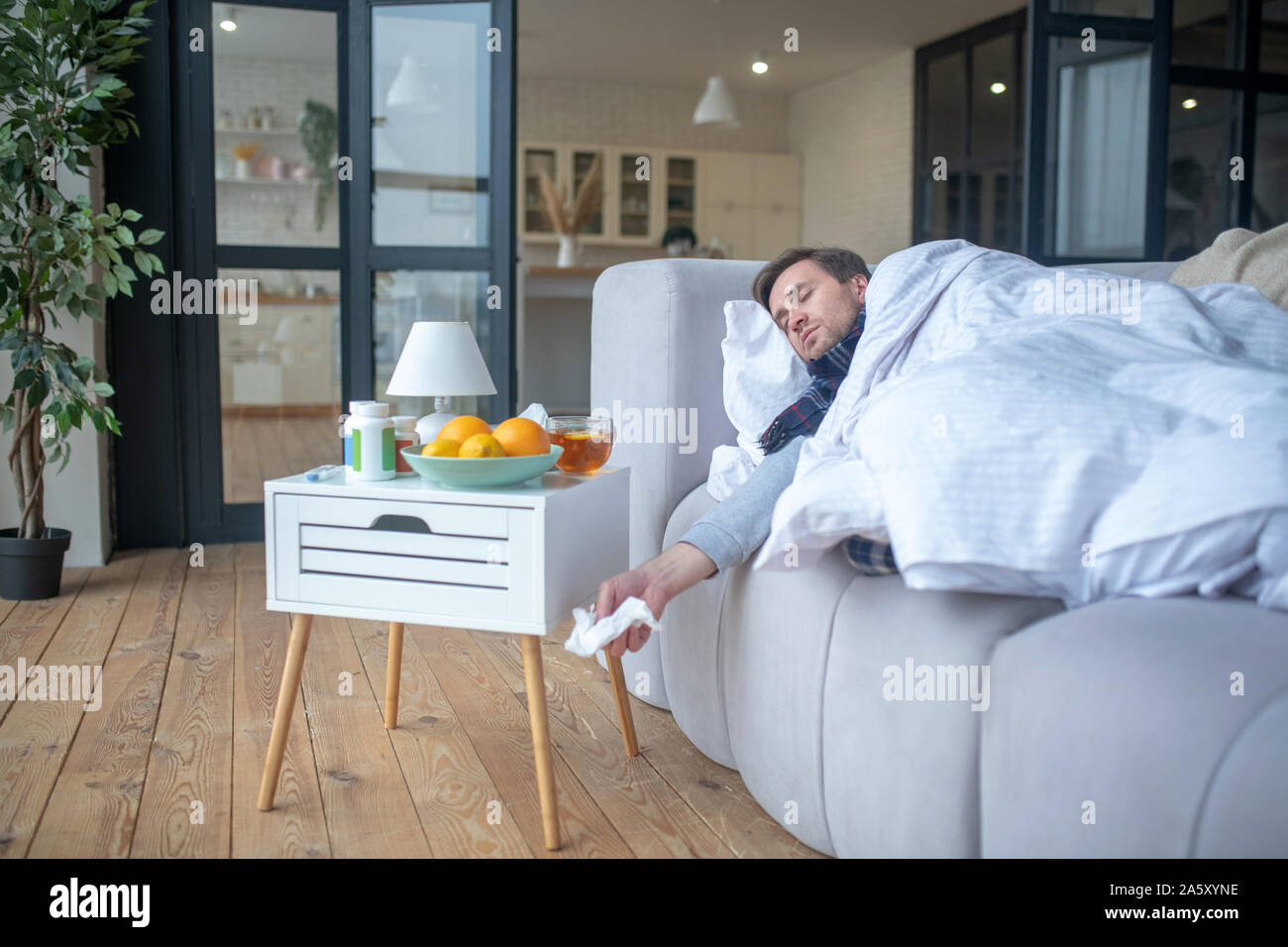 Sick man having napkin in his hand while falling asleep Stock Photo - Alamy