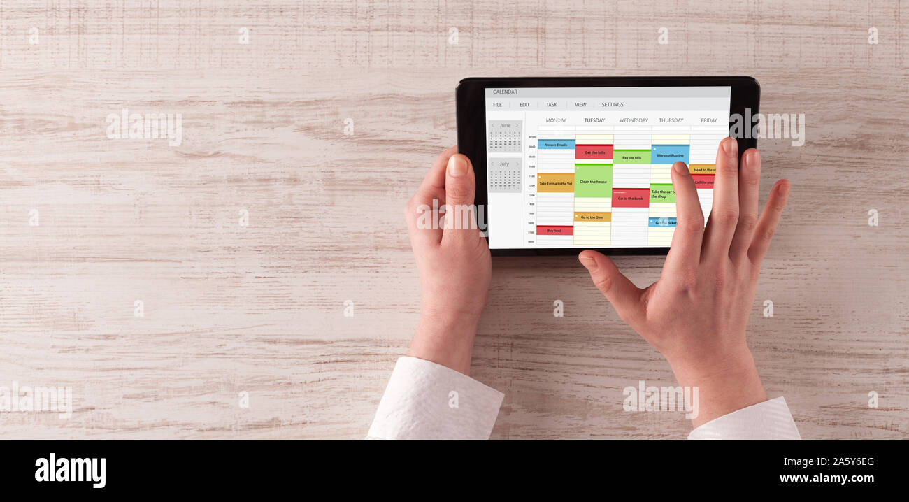 Hand holding tablet with timetable and calendar concept Stock Photo - Alamy