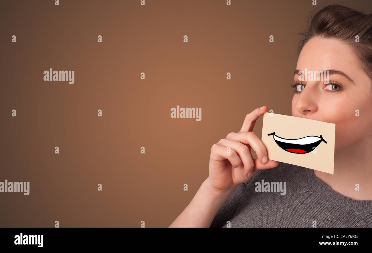 Person holding card in front of his mouth with ironic smile Stock Photo ...