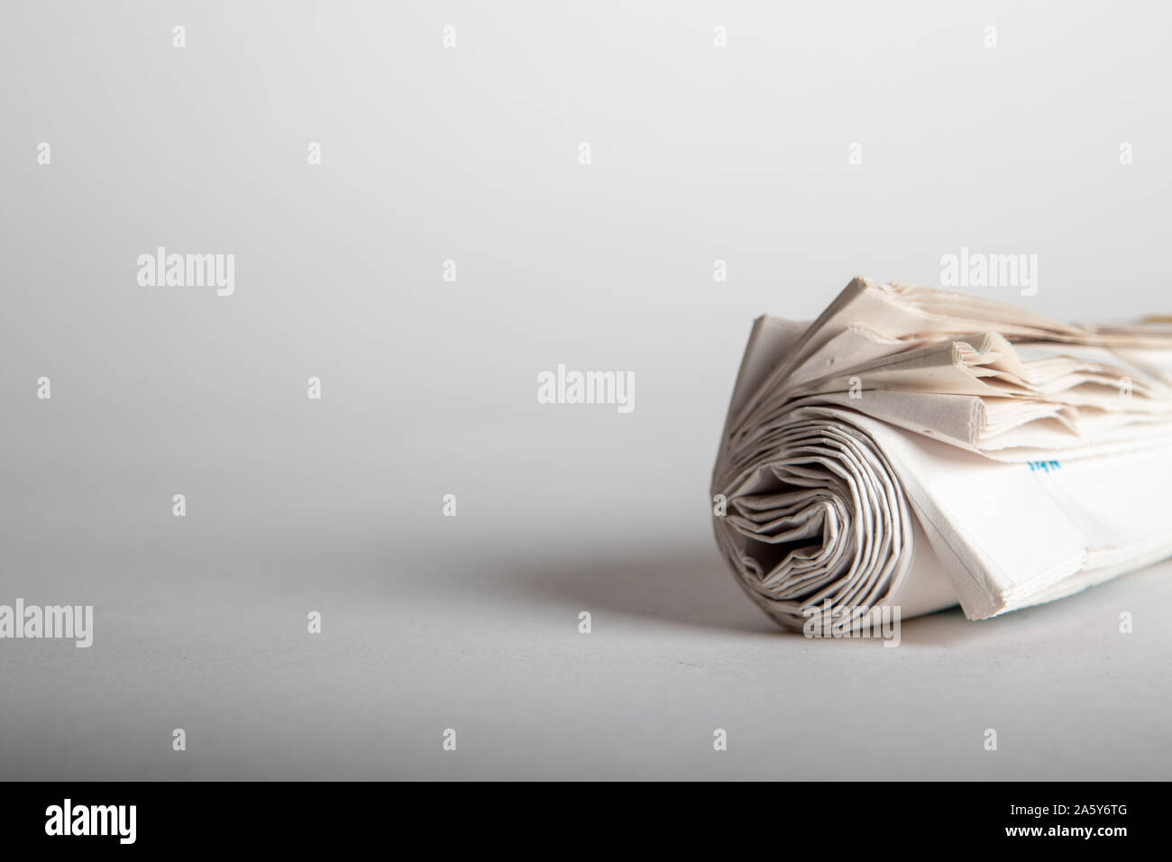 newspaper roll with white background, negative space Stock Photo - Alamy
