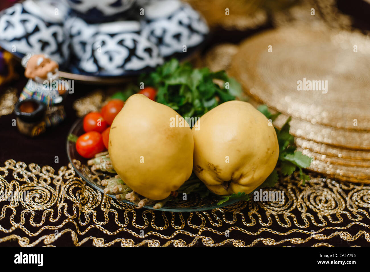 Quince fruits on a table decorated with oriental fabrics with ornaments ...