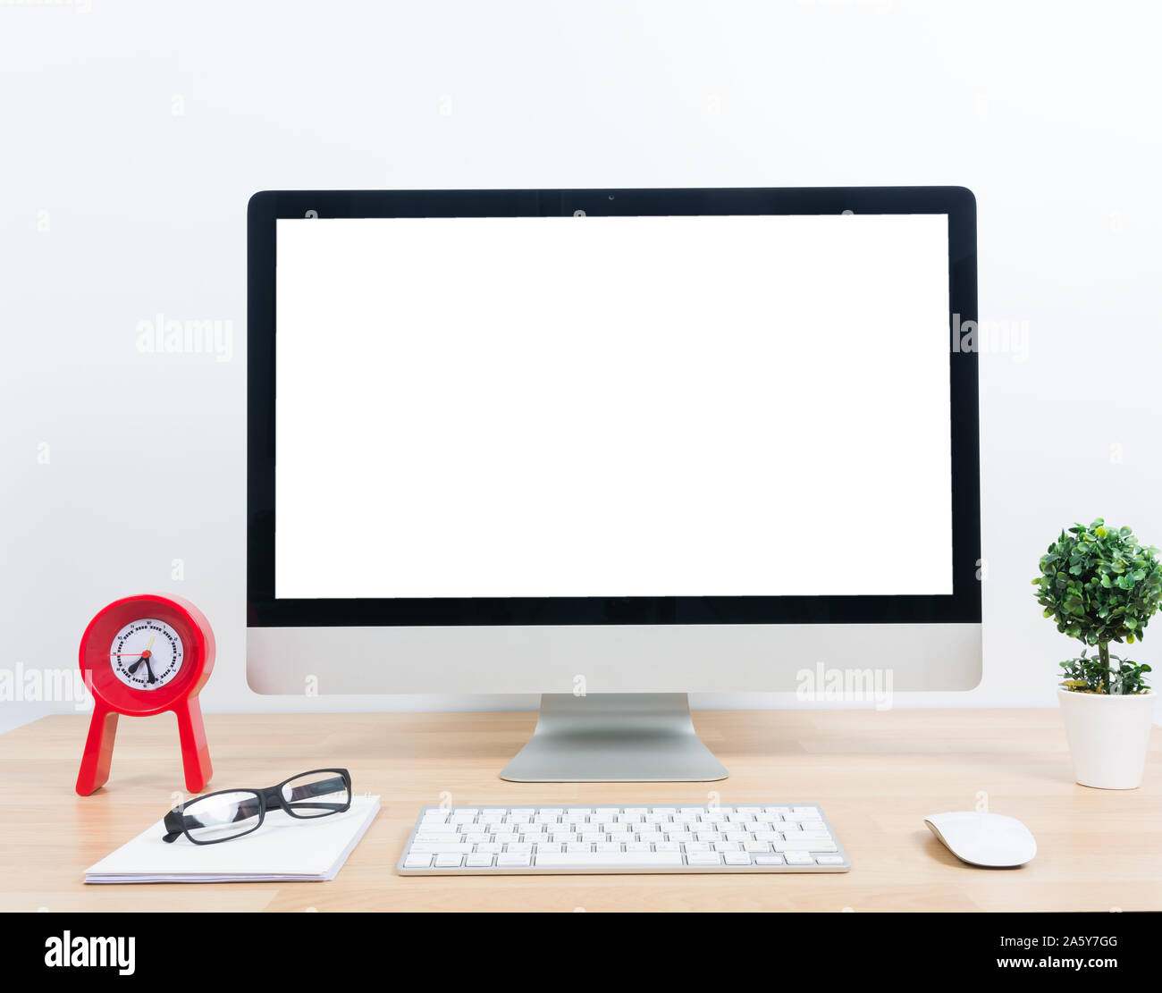 Office monitor computer, mouse on wooden table and white wall ...