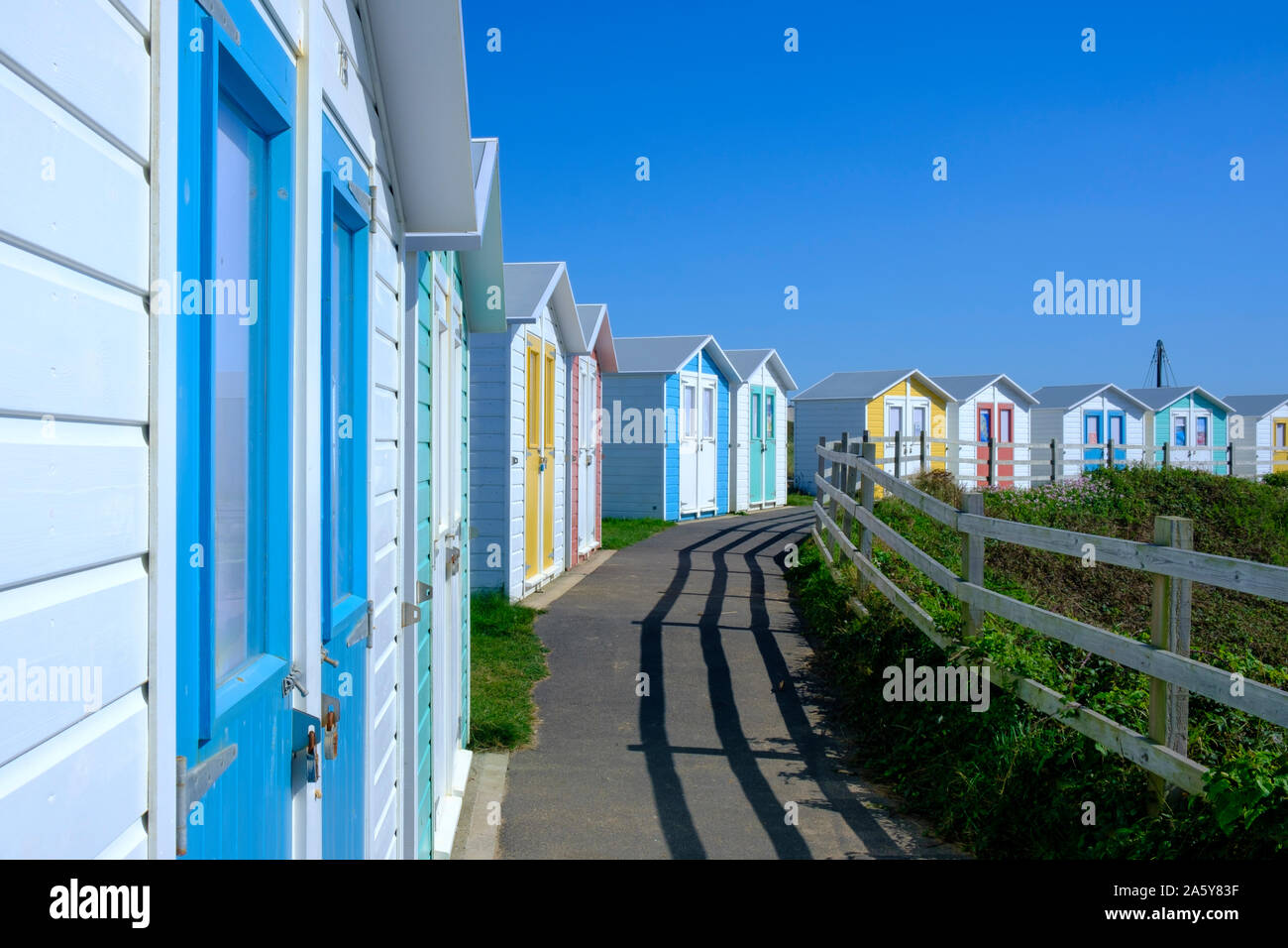 Multi coloured beach huts with boardwalk facing the beach at Bude ...