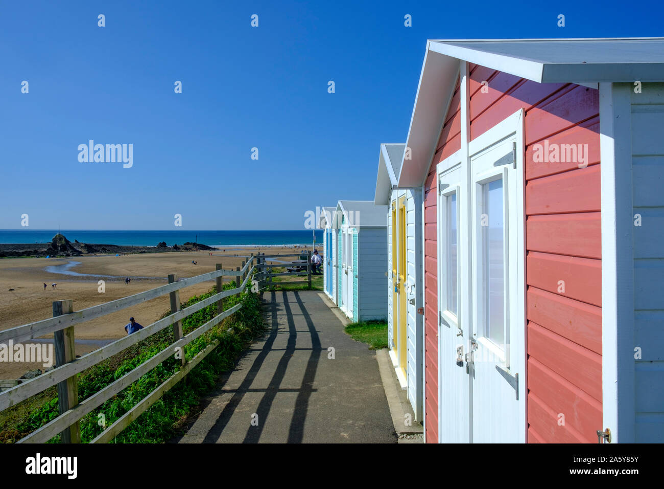 Multi coloured beach huts with boardwalk facing the beach at Bude ...