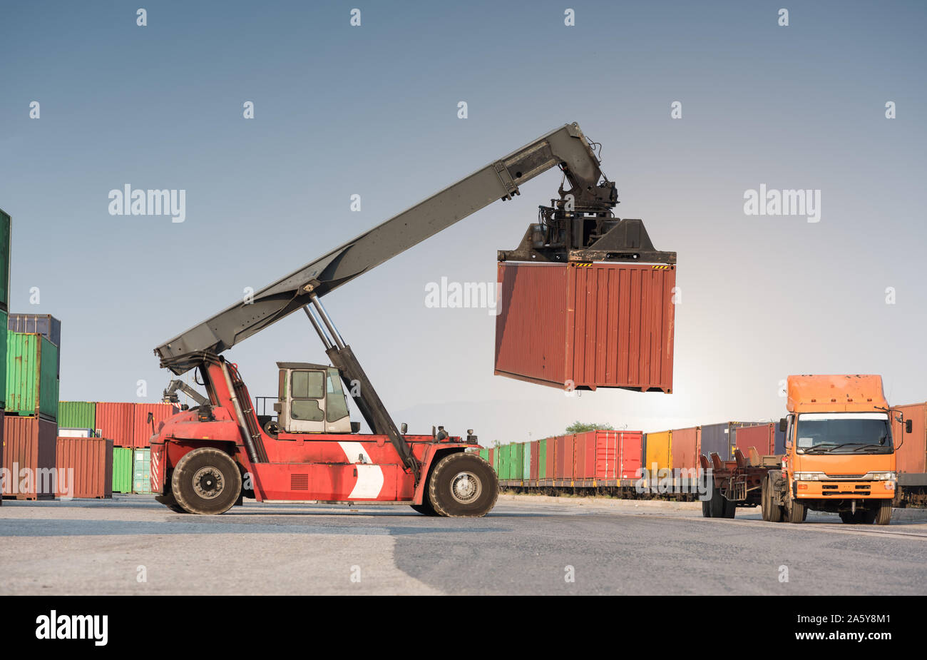 forklift handling container loading box from freight train to the truck ...