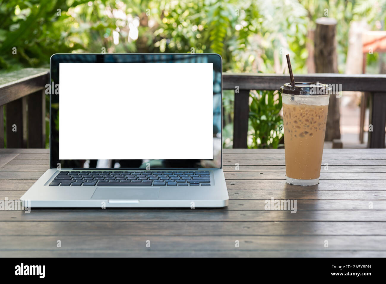 Laptop Notebook with iced coffee cup on wooden table in coffee shop and ...