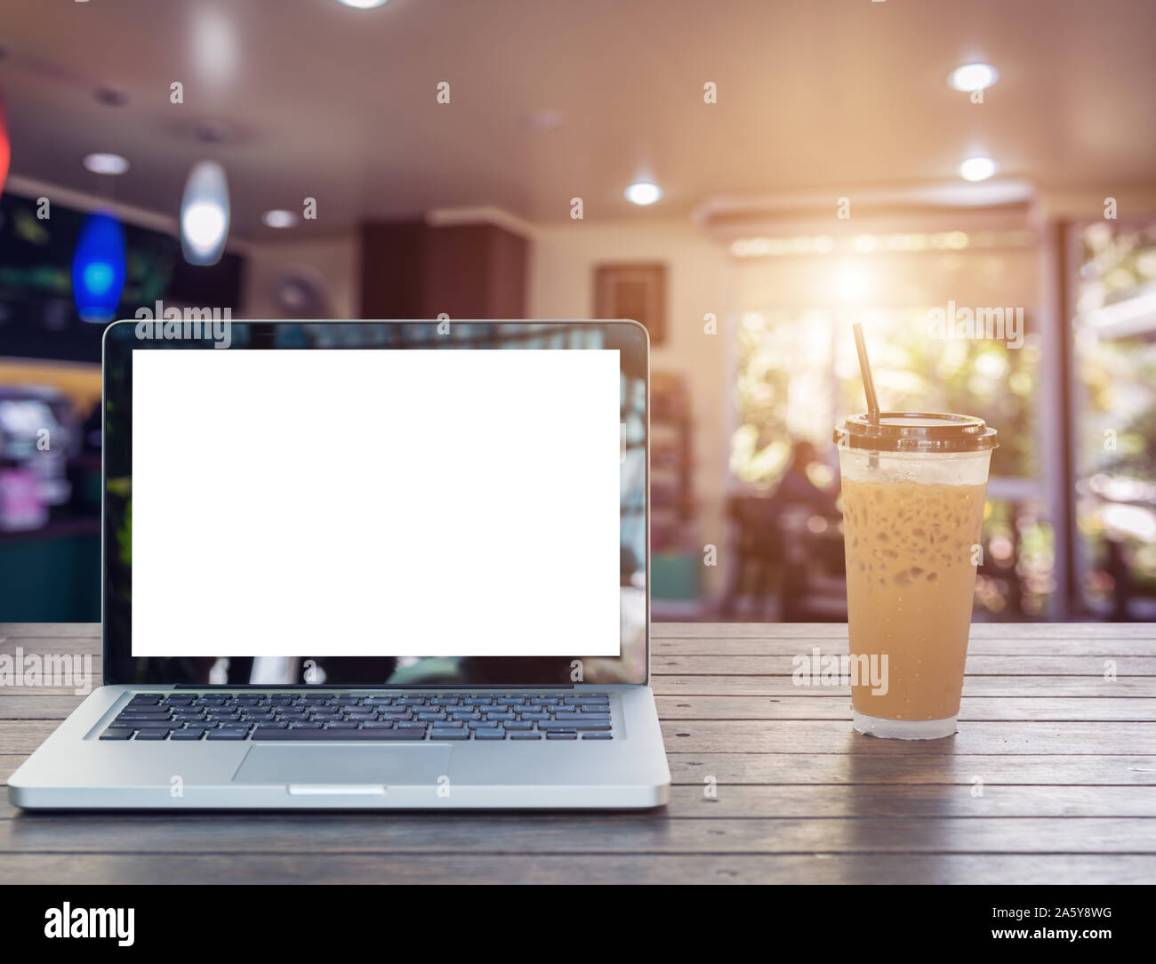 Laptop Notebook with iced coffee cup on wooden table in coffee shop ...