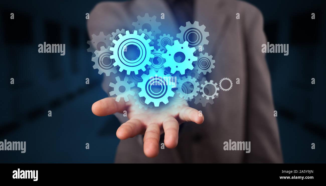 Hand holding gears in his hand Stock Photo - Alamy