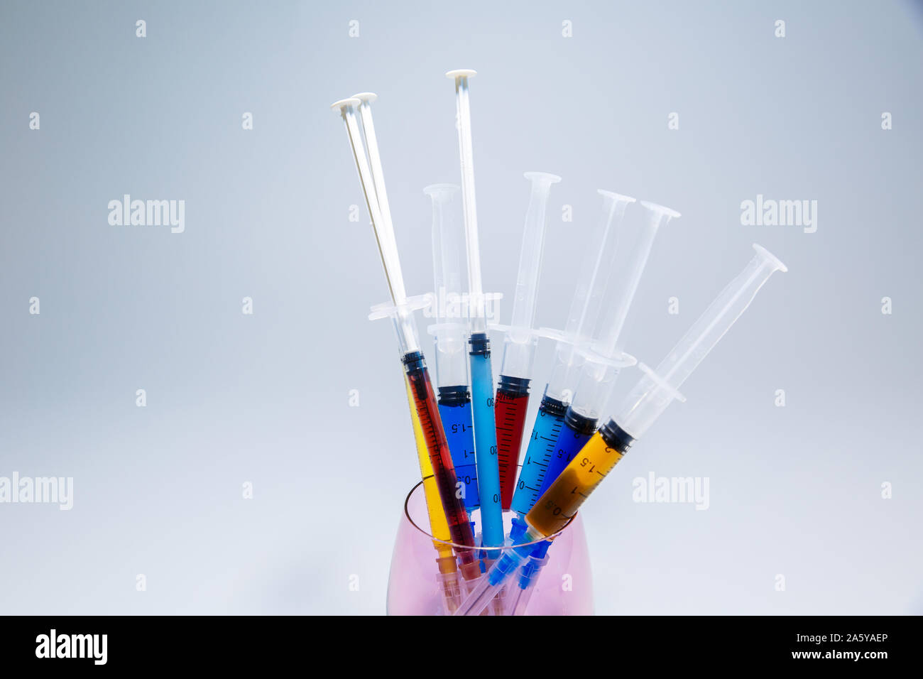 Set of medical syringes in a glass with colored injections for ...