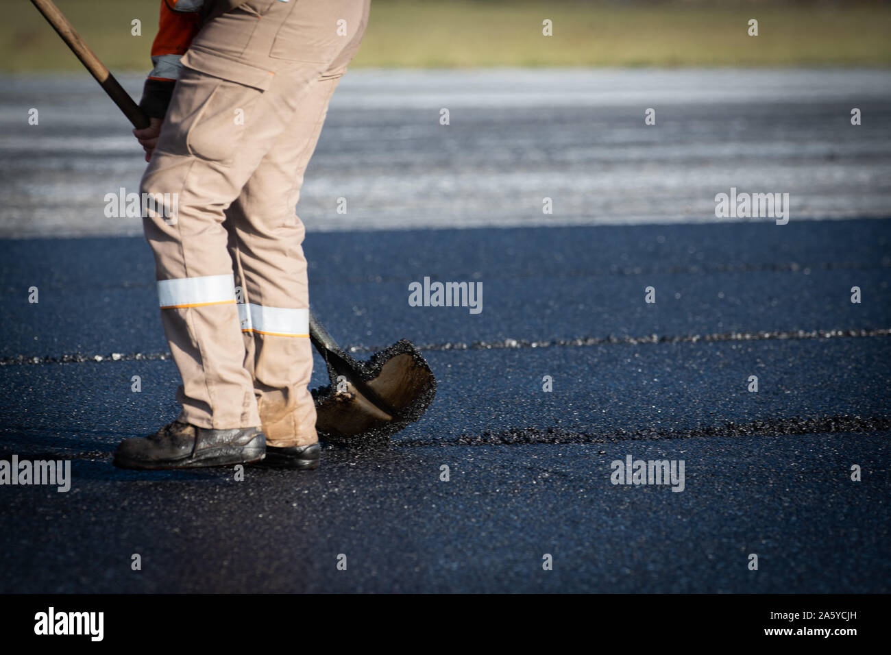 Worker with roller compacting asphalt on a road Stock Photo - Alamy