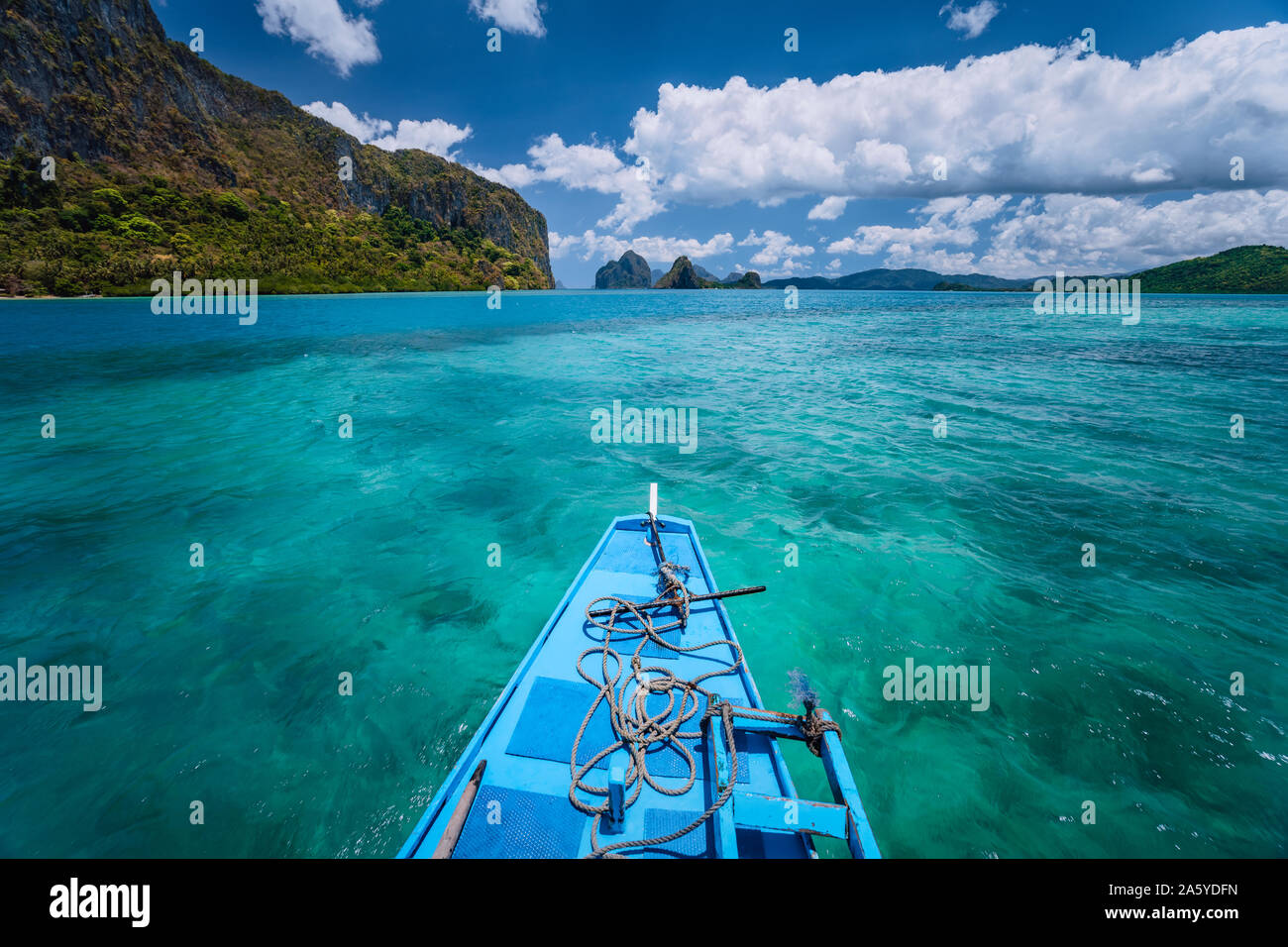 Island hopping Tour boat hover over open blue ocean water between ...