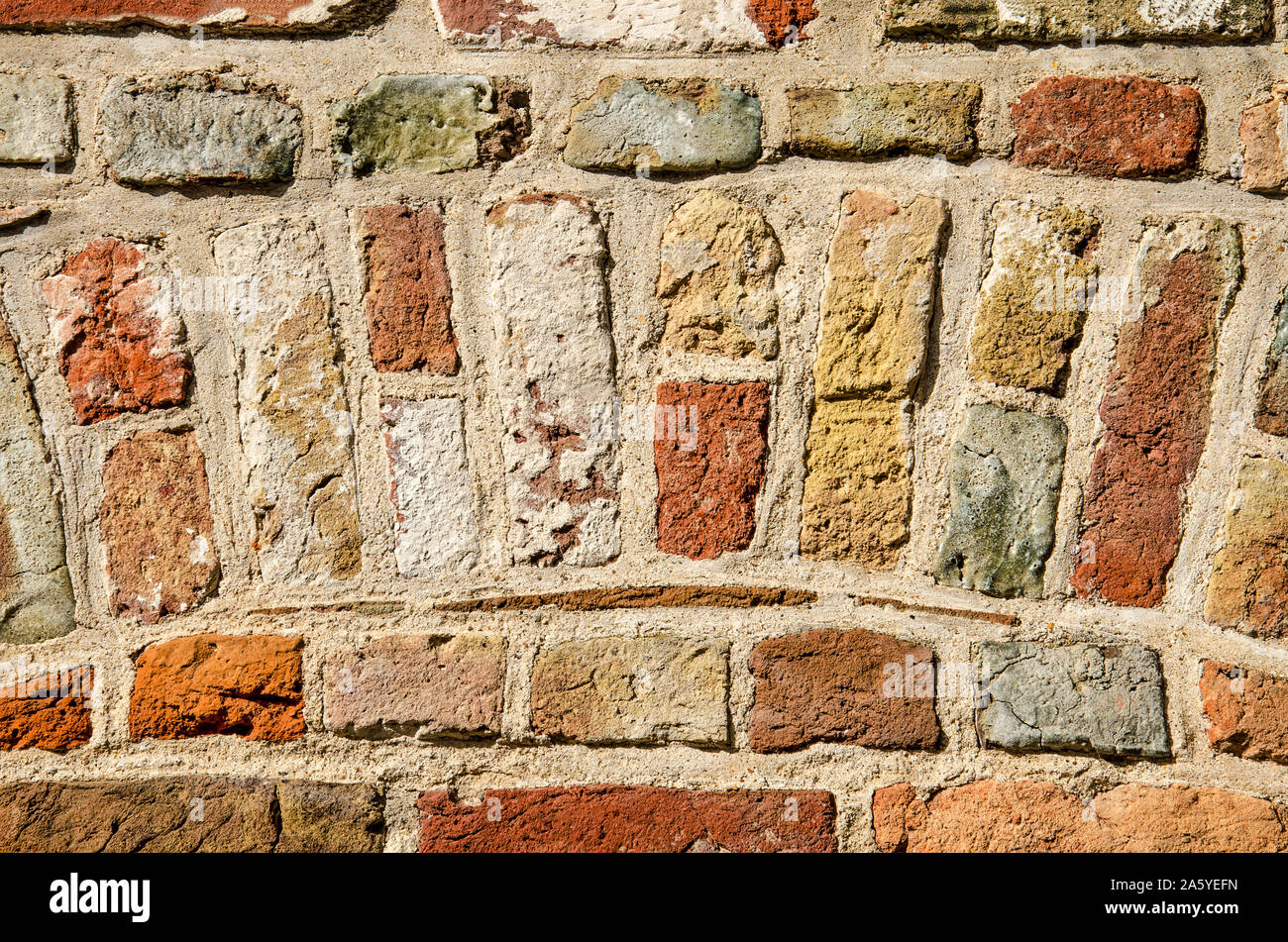 Section of a colorful brick wall with a row a bricks applied vertically ...