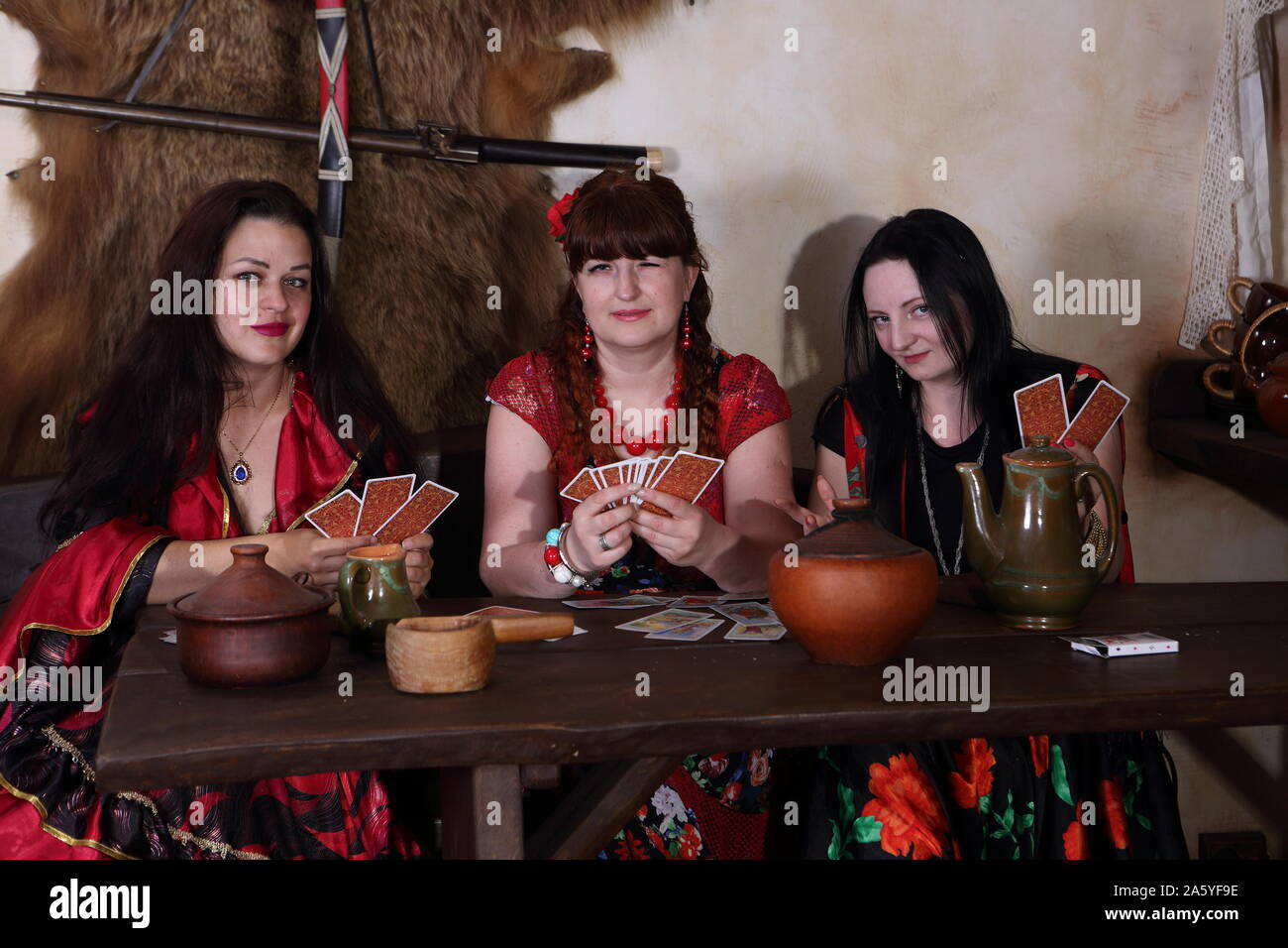 Three beautiful gypsies sit at a table in the kitchen Stock Photo - Alamy