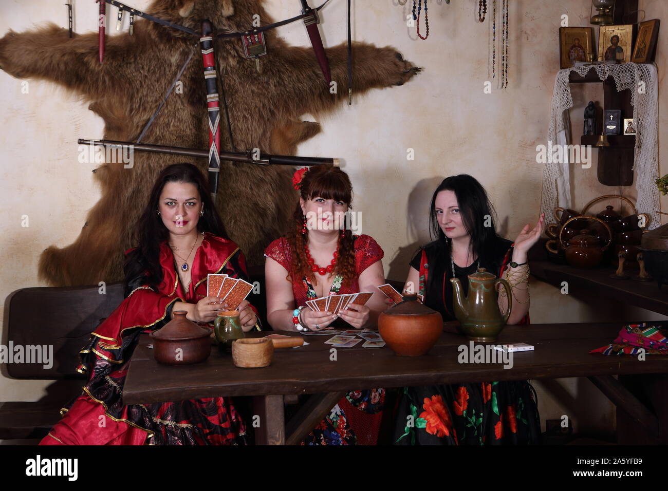 Three beautiful gypsies sit at a table in the kitchen Stock Photo - Alamy