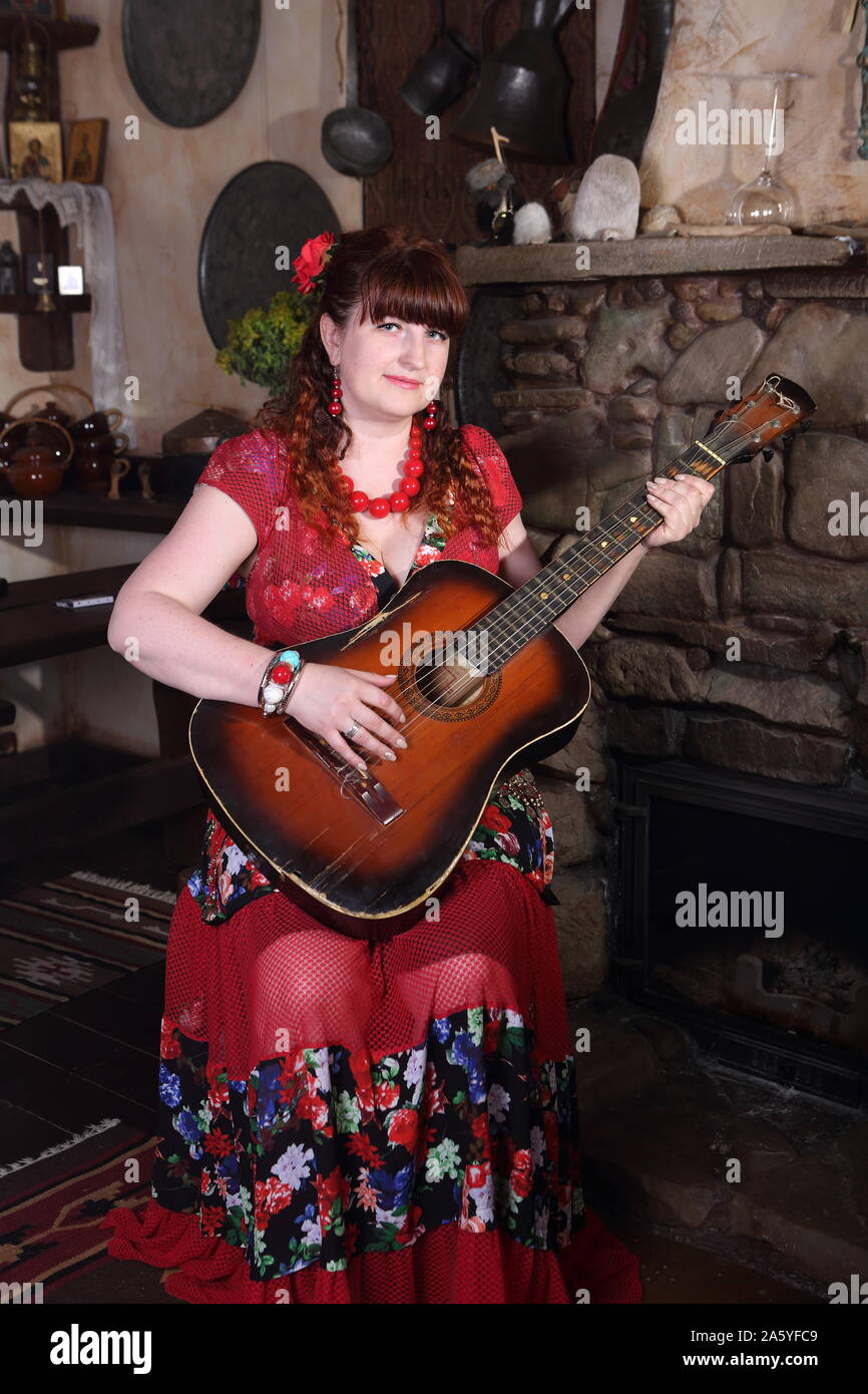 Beautiful young gypsy woman plays the guitar Stock Photo - Alamy