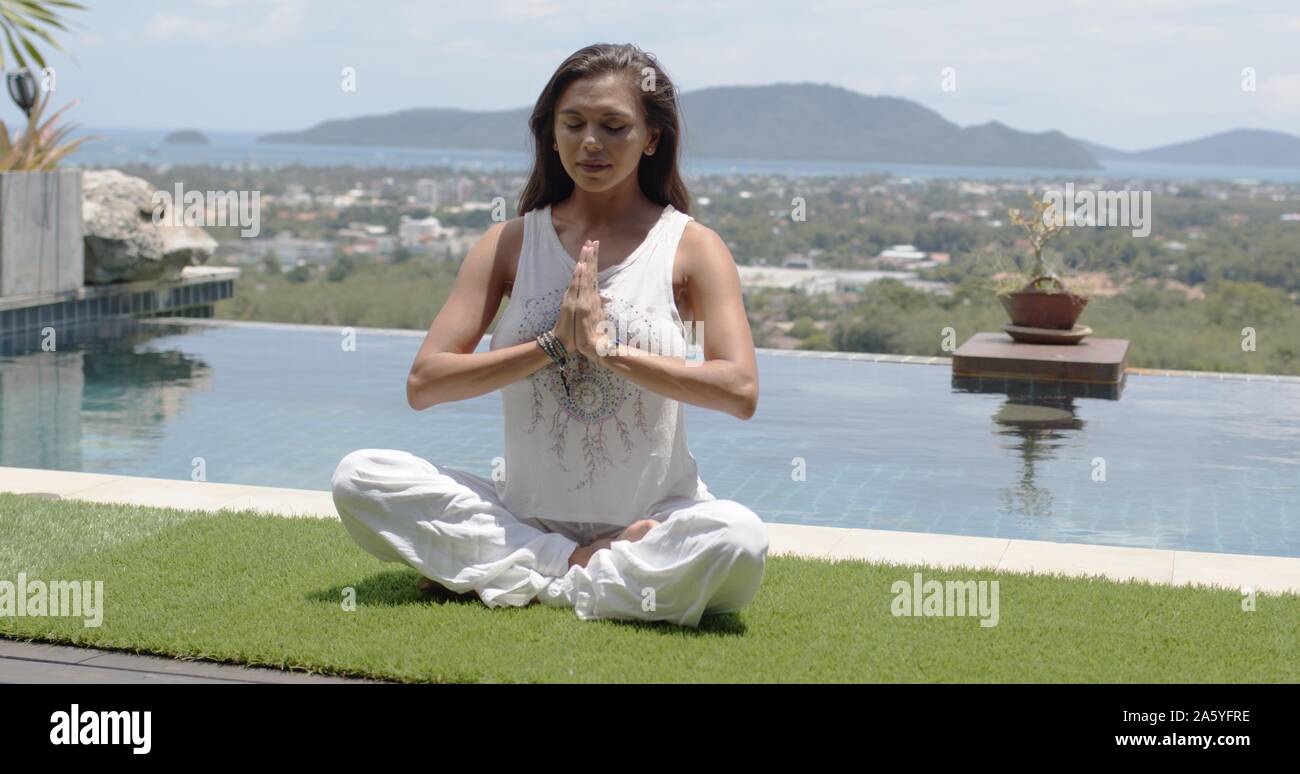 Calm lady sitting in lotus position at resort Stock Photo - Alamy