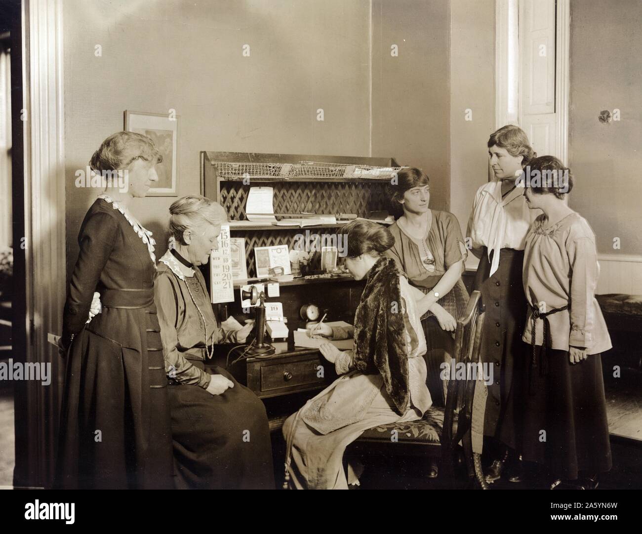 Six National Woman's Party members gathered around a desk at National ...