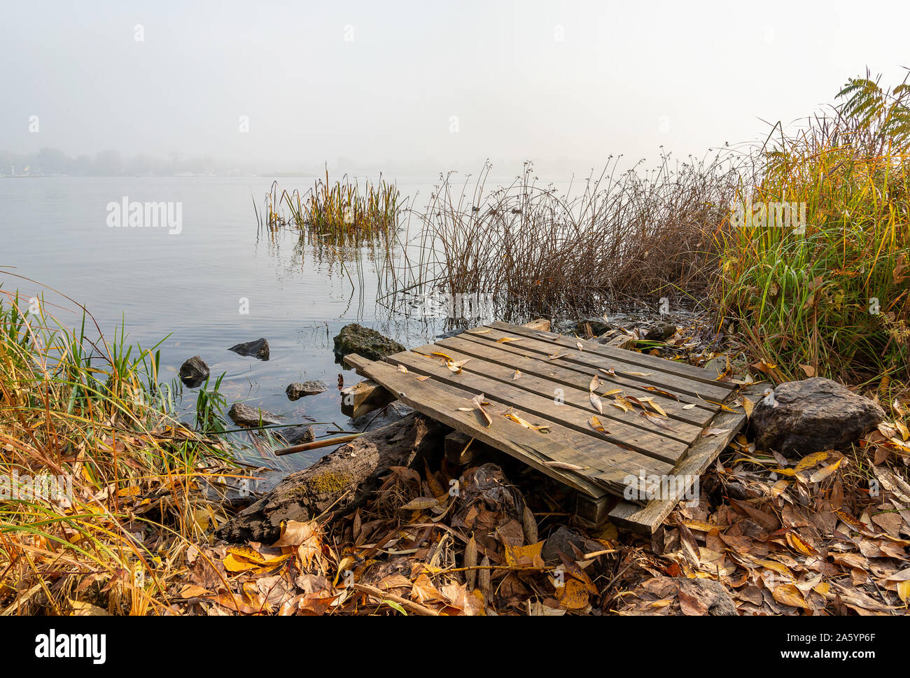 A wooden pontoon over big stones close to the blue Dnieper river is ...