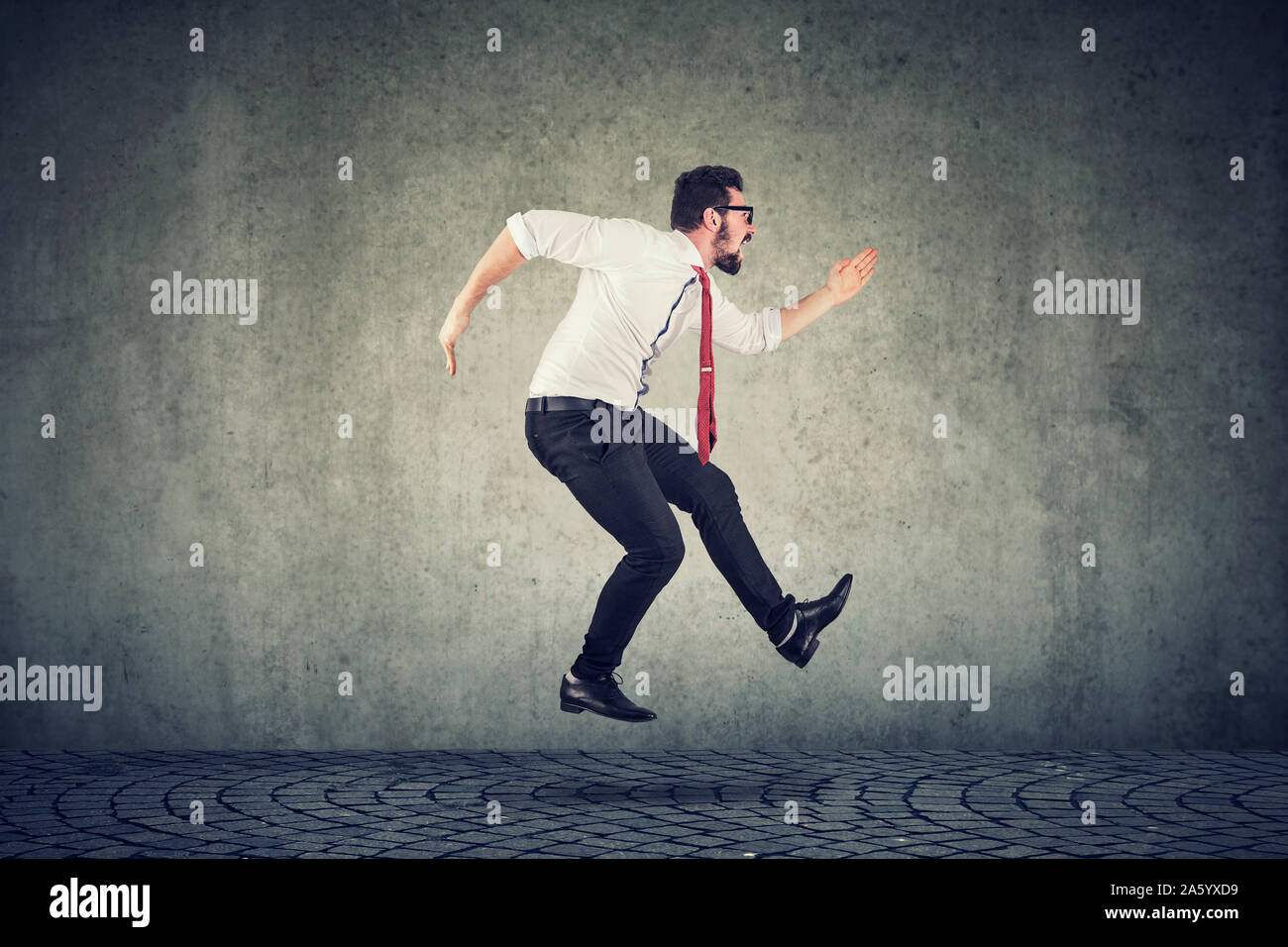 Young business man running jumping against wall background Stock Photo ...