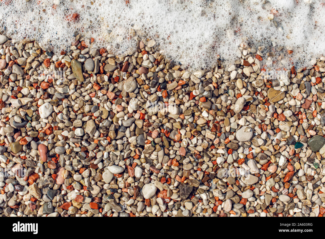 Wet colorful pebble on shore of Mediterranean Sea background, top view ...