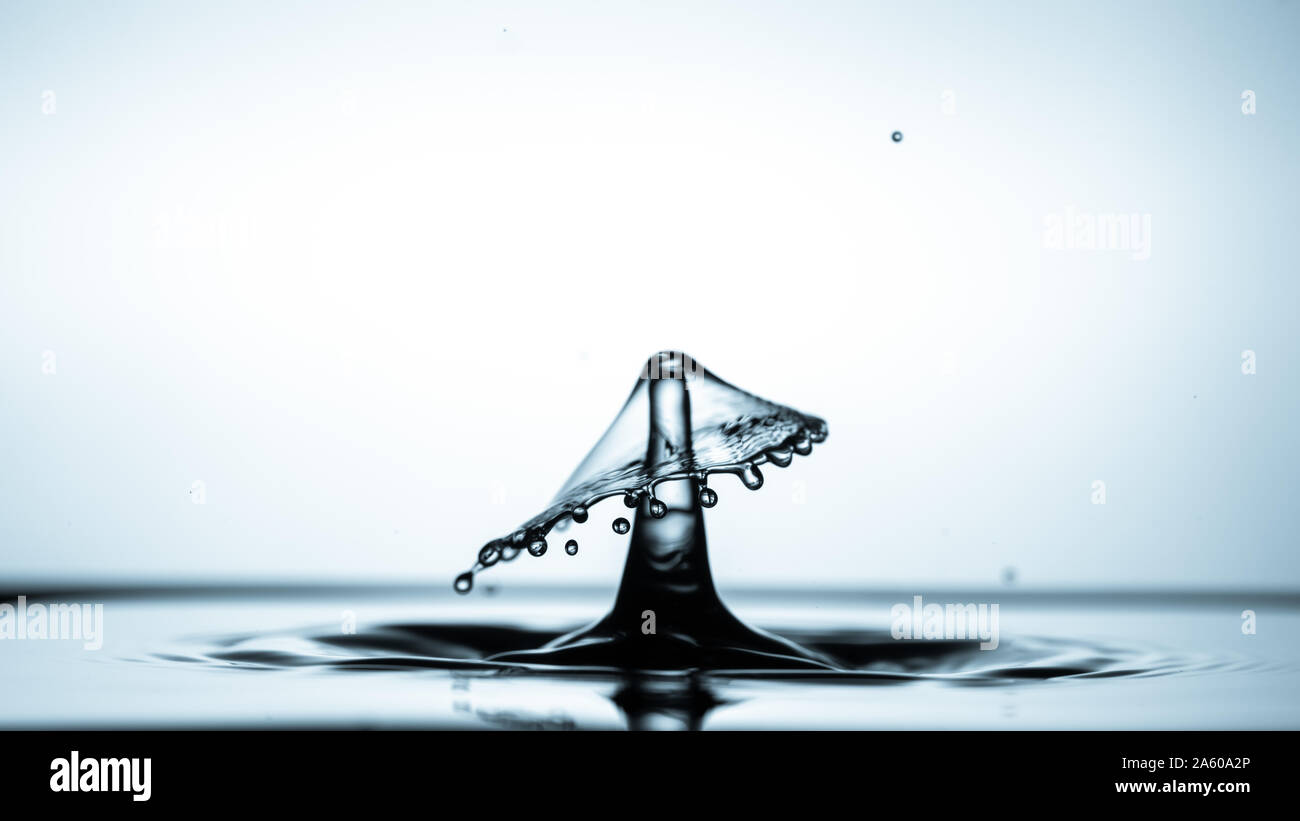 Close-up of a water drop falling on water surface Stock Photo - Alamy