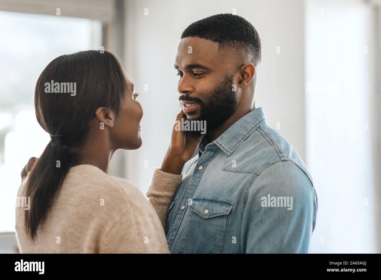 Romantic young African American couple standing lovingly together at ...