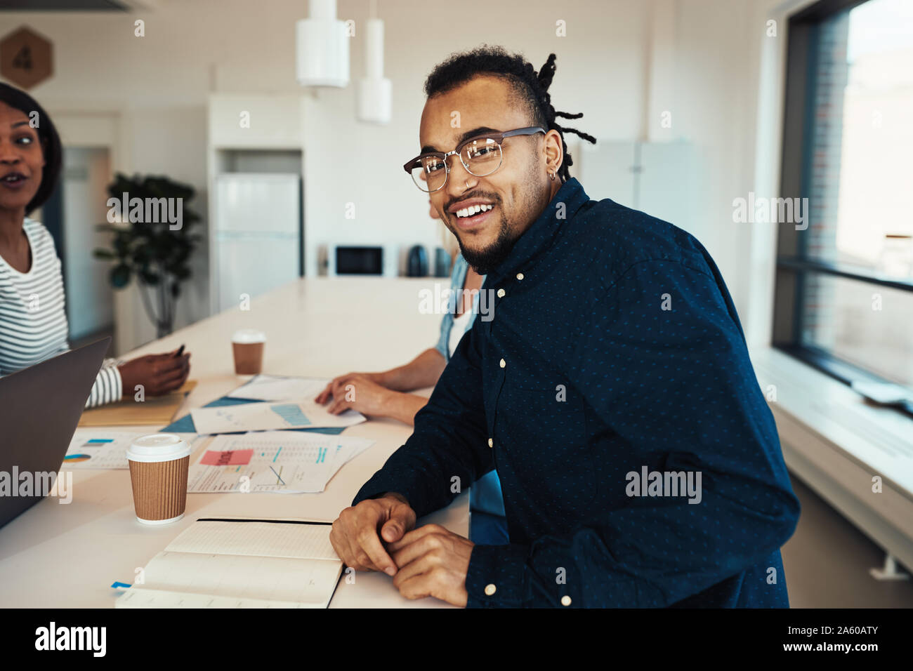 Young African American business professional smiling while sitting with ...