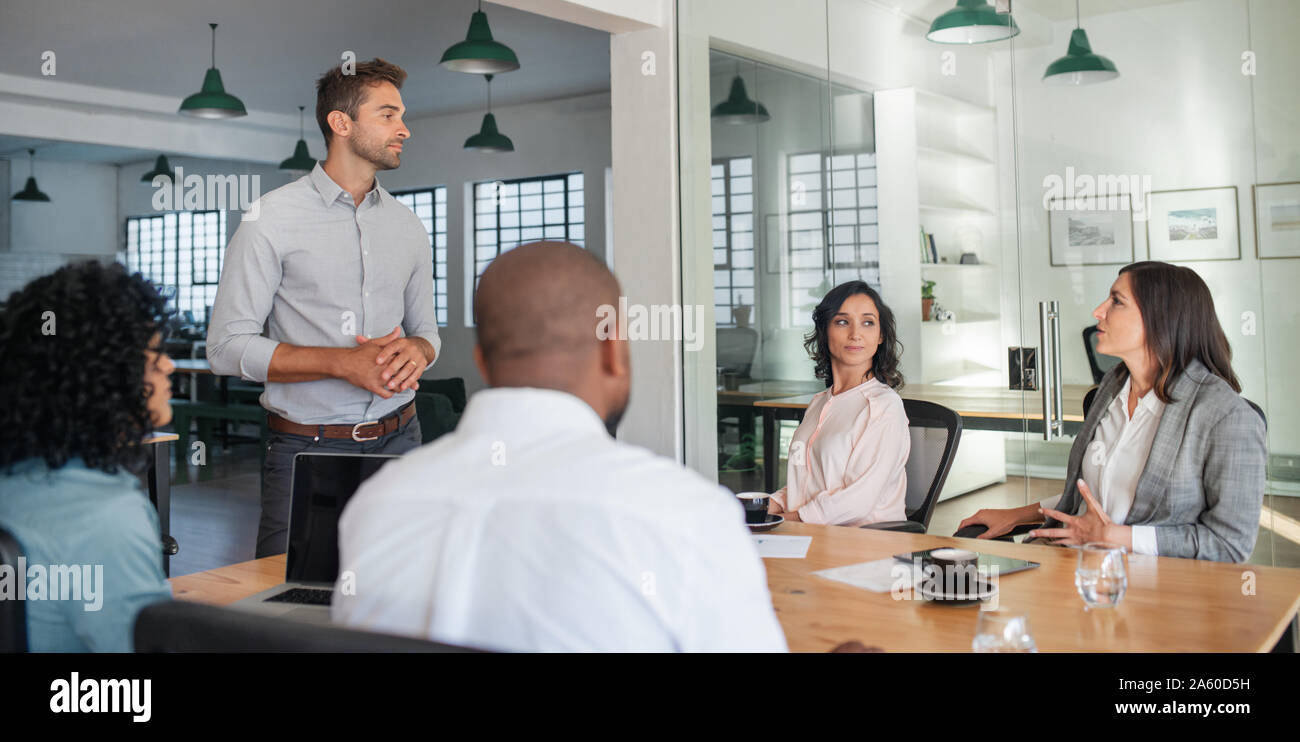 Staff asking their manager questions during an office meeting Stock ...
