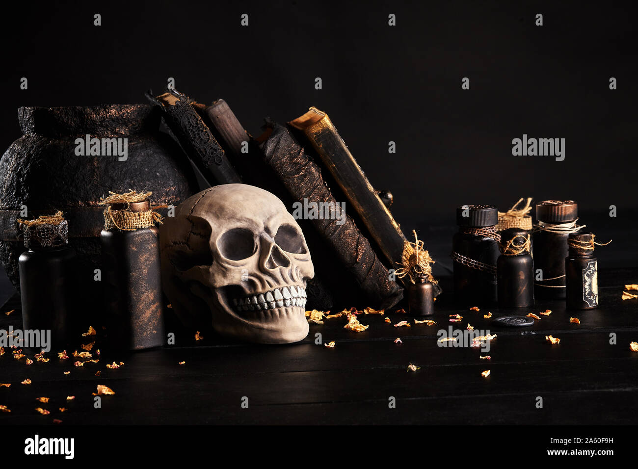 Realistic model of a human brainpan with white teeth, old pot, books ...