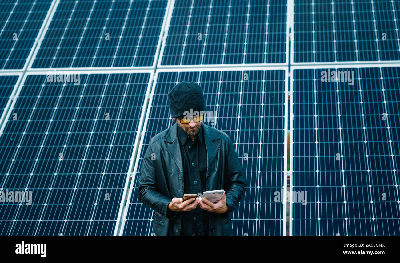 Man stand beside of solar panels with tablets in hands, and check ...