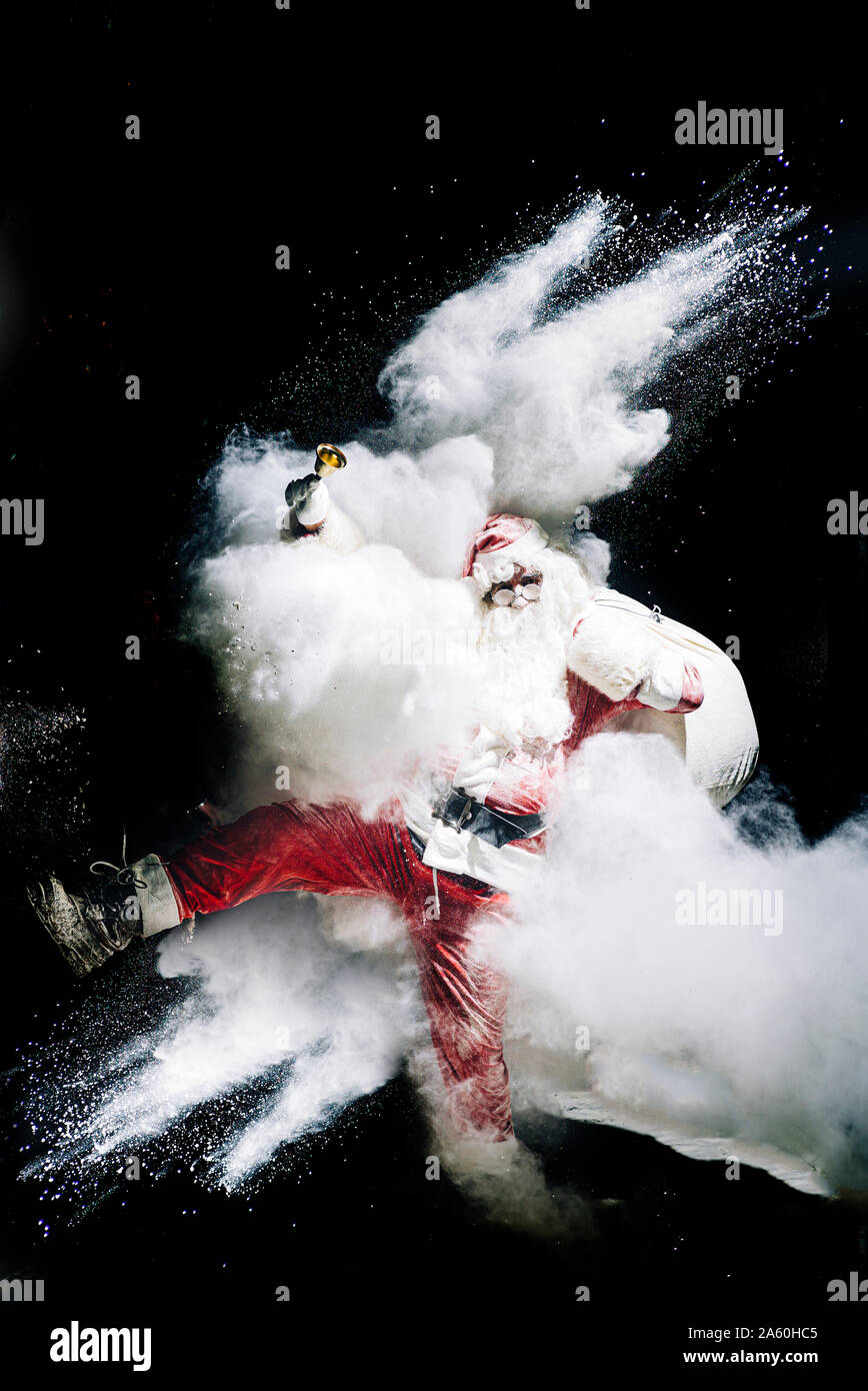 Santa Claus with exploding snow bomb against black background Stock ...