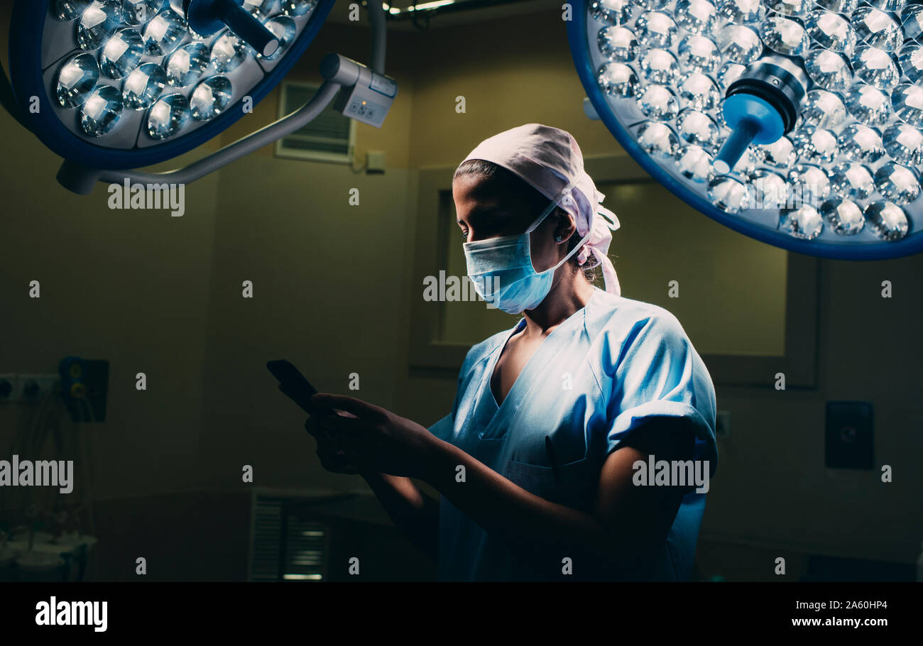 Nurse using a mobile phone in operating room Stock Photo - Alamy