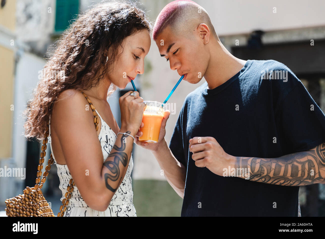 Young couple drinking fruit juice together Stock Photo - Alamy