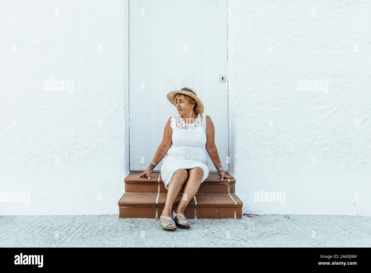 Senior tourist sitting on stoop in a village hi-res stock photography ...