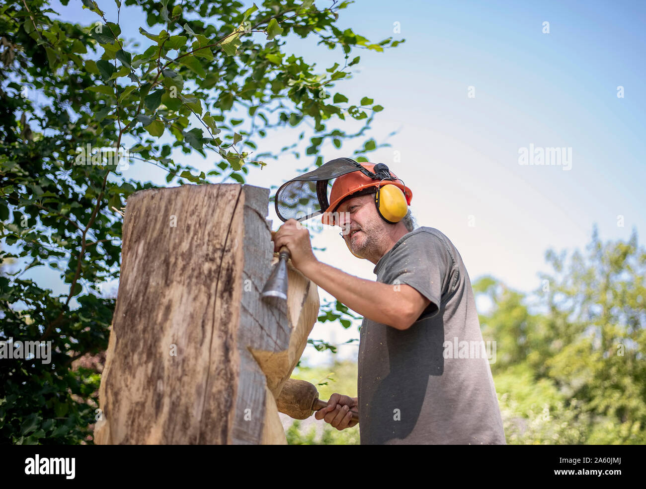 Wood carver carving sculpture, using chisel Stock Photo - Alamy