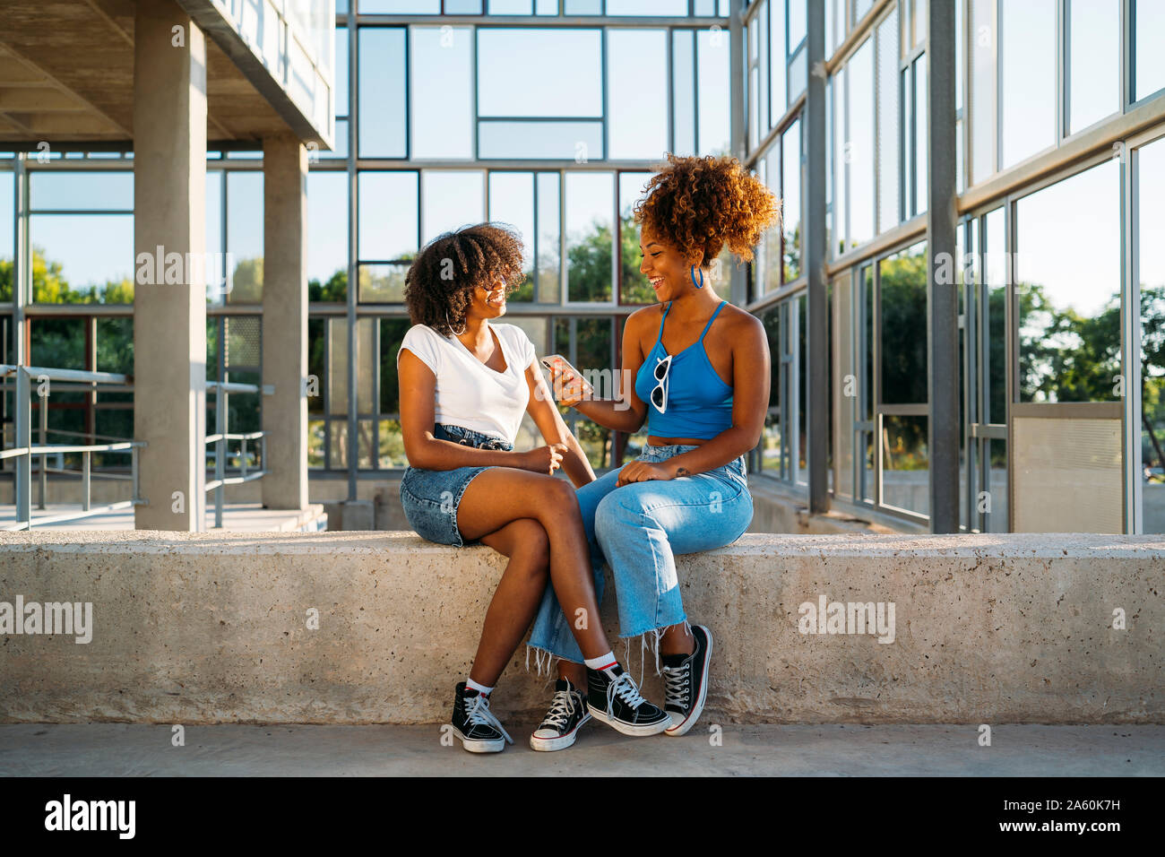 Two people sitting on a wall hi-res stock photography and images - Alamy
